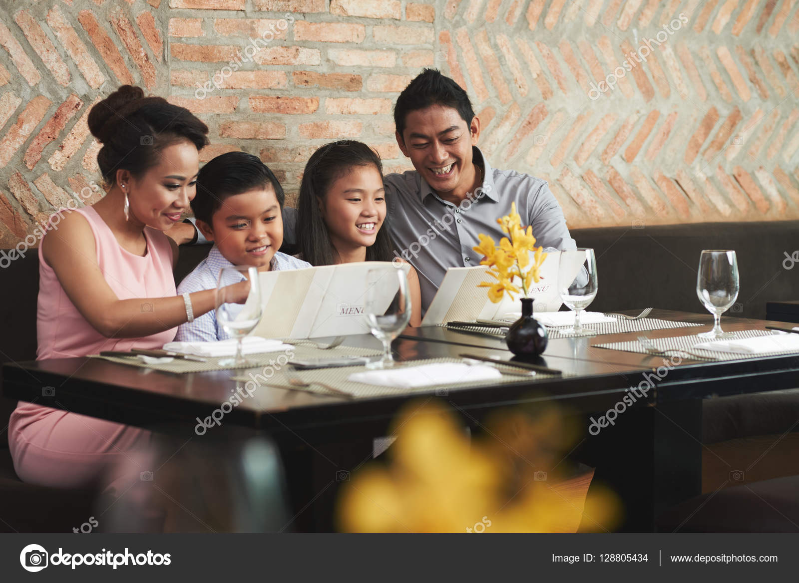 Family reading menu at restaurant Stock Photo by ©DragonImages 128805434