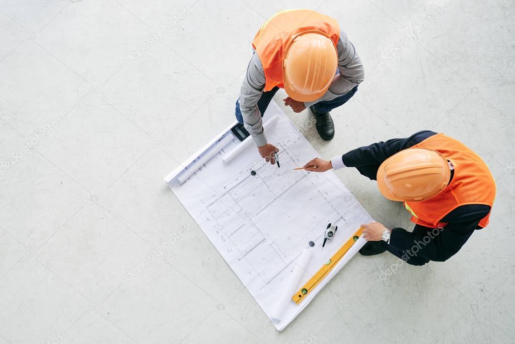 Engineers discussing blueprint of building — Stock Photo © DragonImages ...