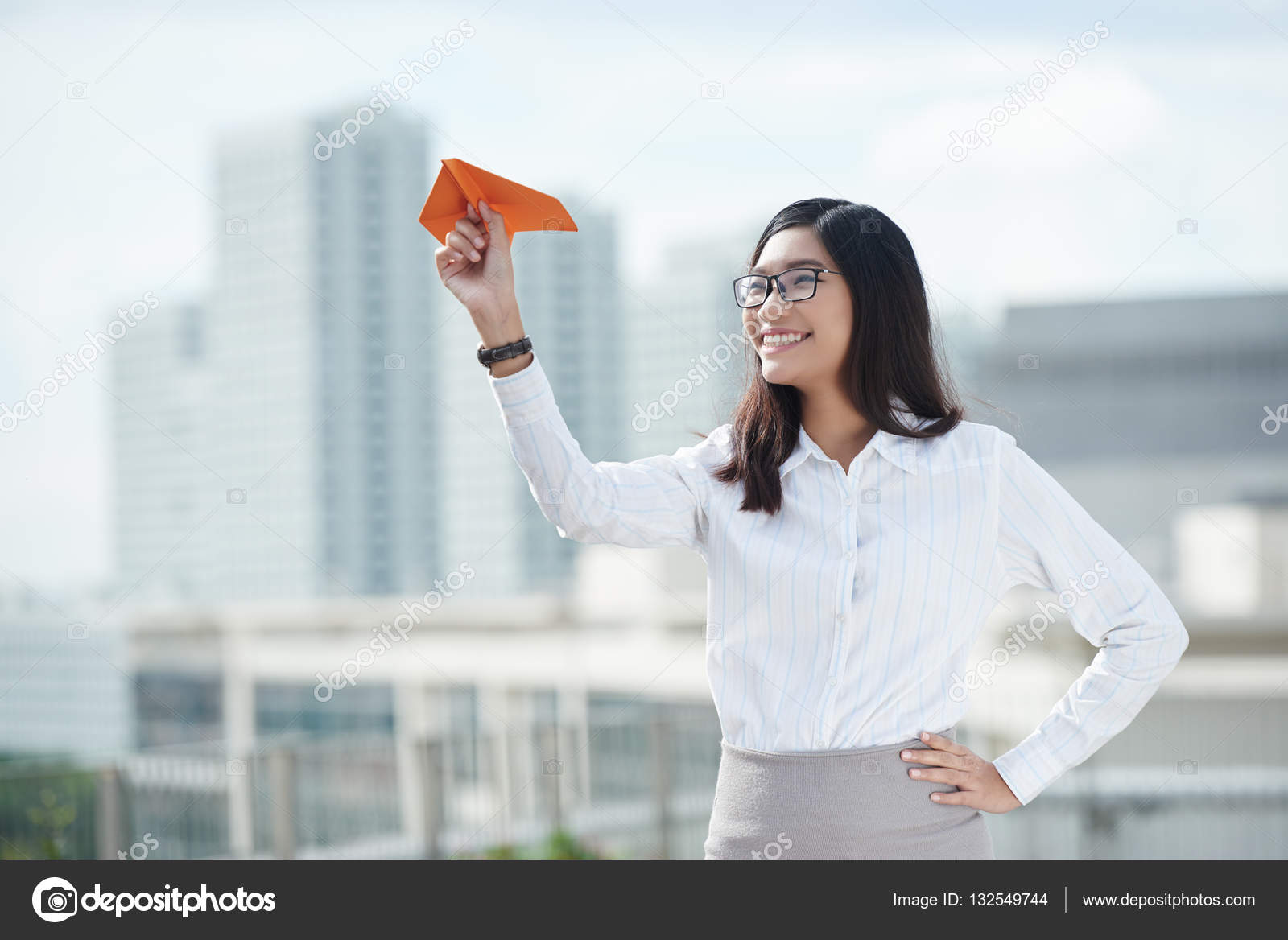 Woman launching paper airplane Stock Photo by ©DragonImages 132549744
