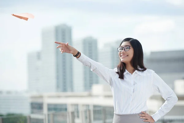 Woman launching paper airplane Stock Photo by ©DragonImages 132549744