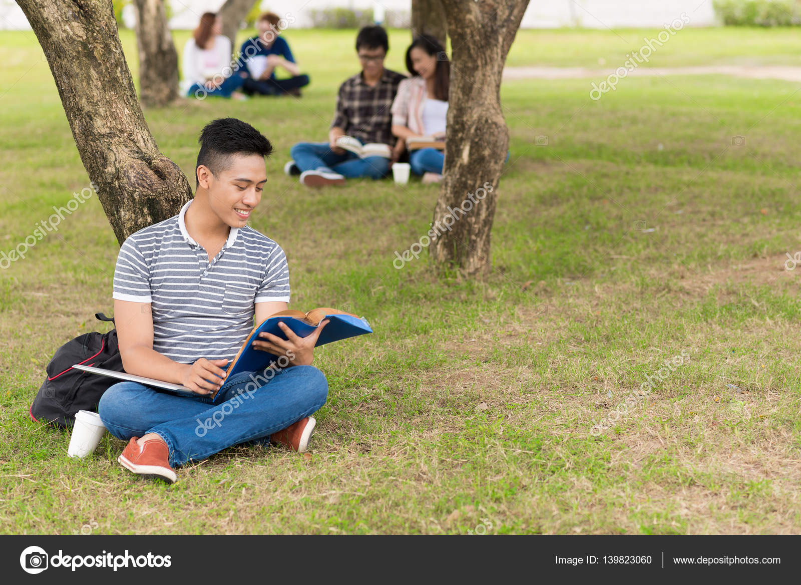 Student sitting and reading book — Stock Photo © DragonImages #139823060