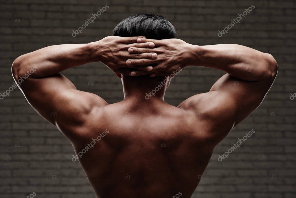 Muscular man holding hands behind head — Stock Photo © DragonImages ...