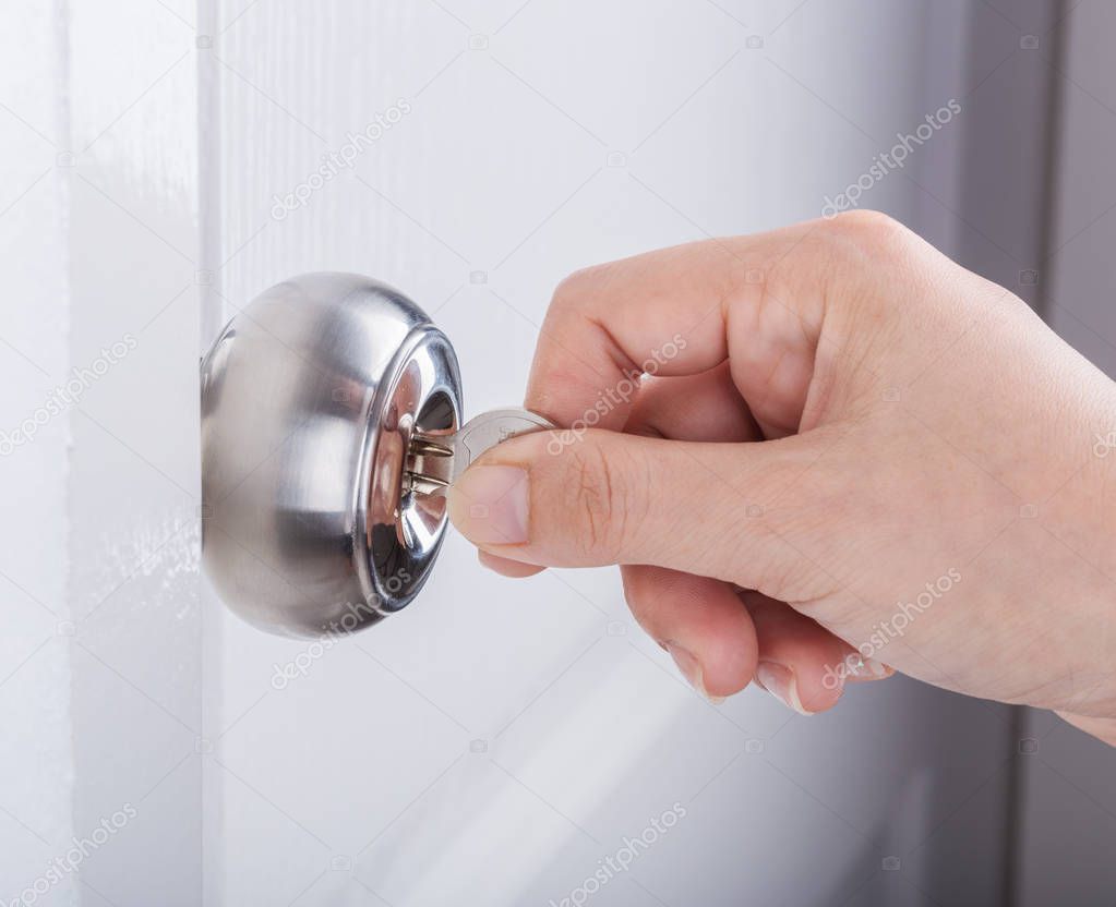 Mano utilizar la llave para desbloquear la perilla de la puerta en la ...