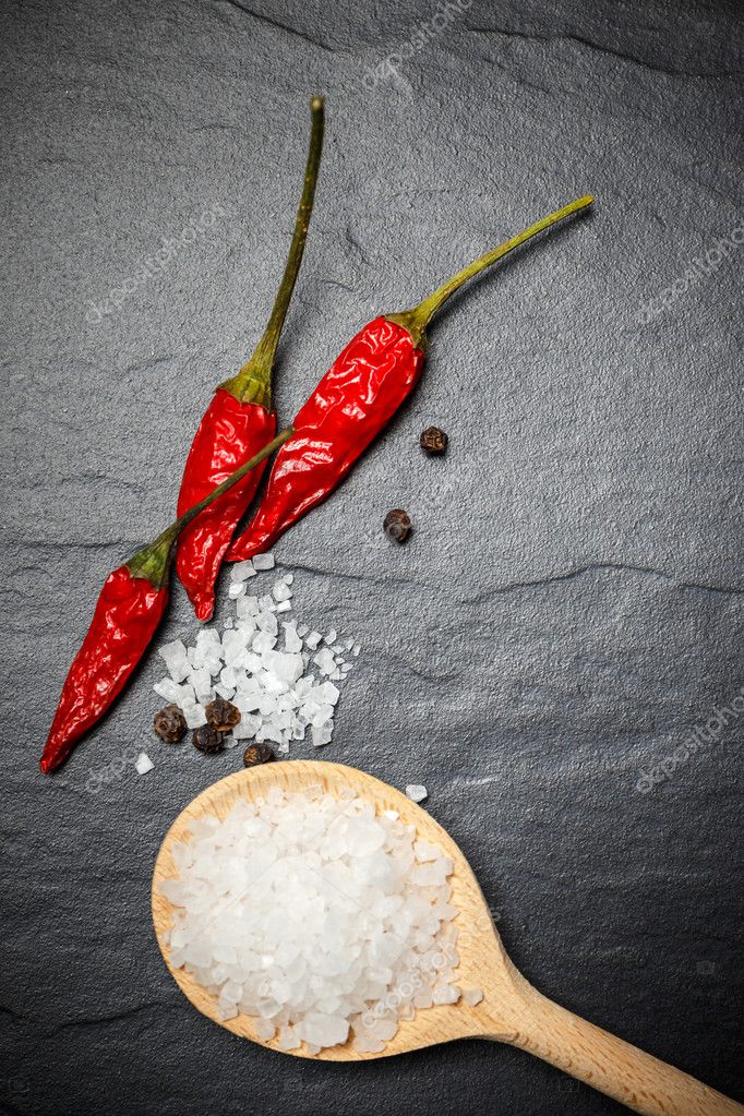 Chili with black pepper and salt on rustic stone background. Overhead ...
