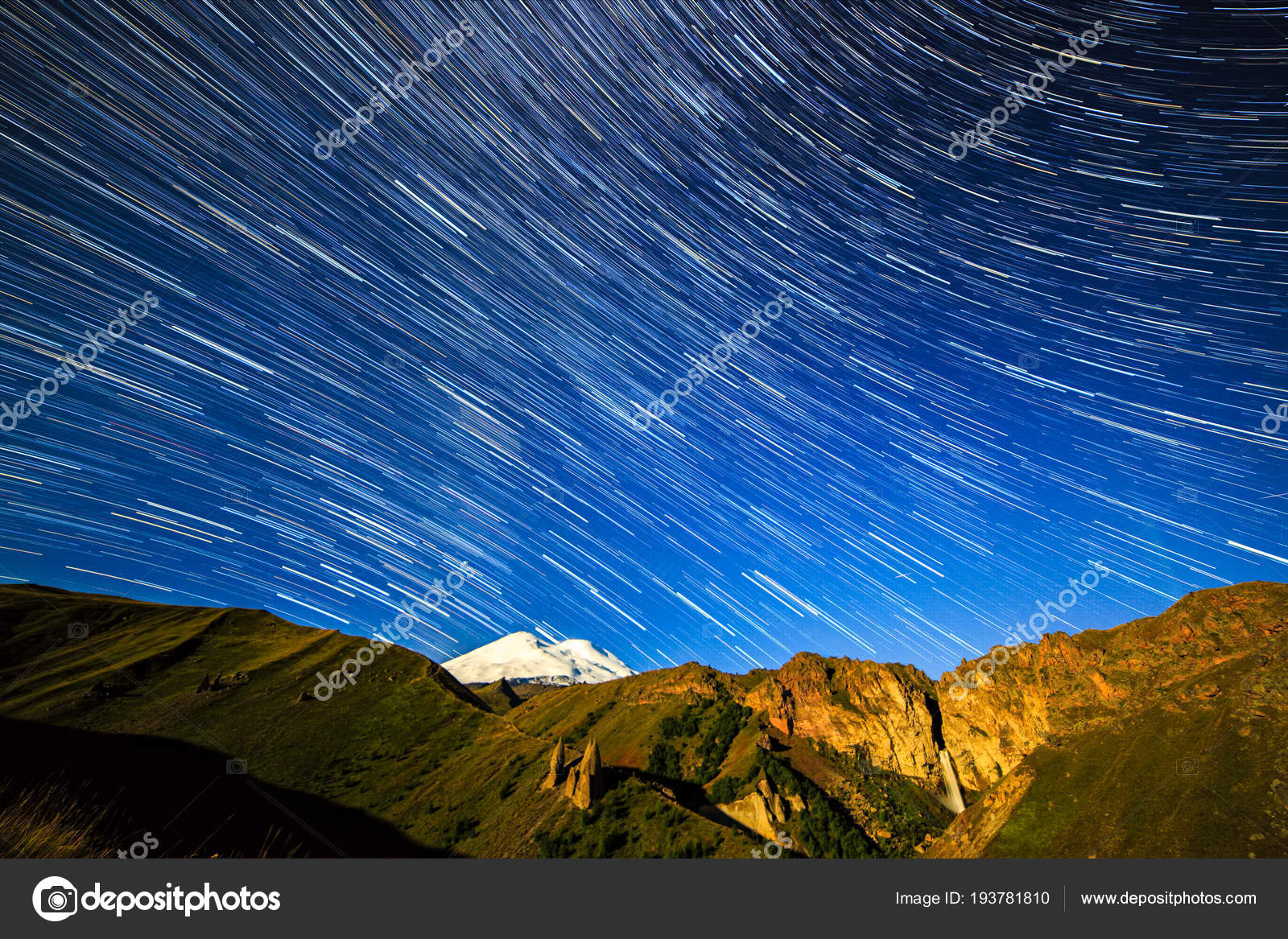Stars draw fading lines and clouds over Mount Elbrus. Night land Stock ...
