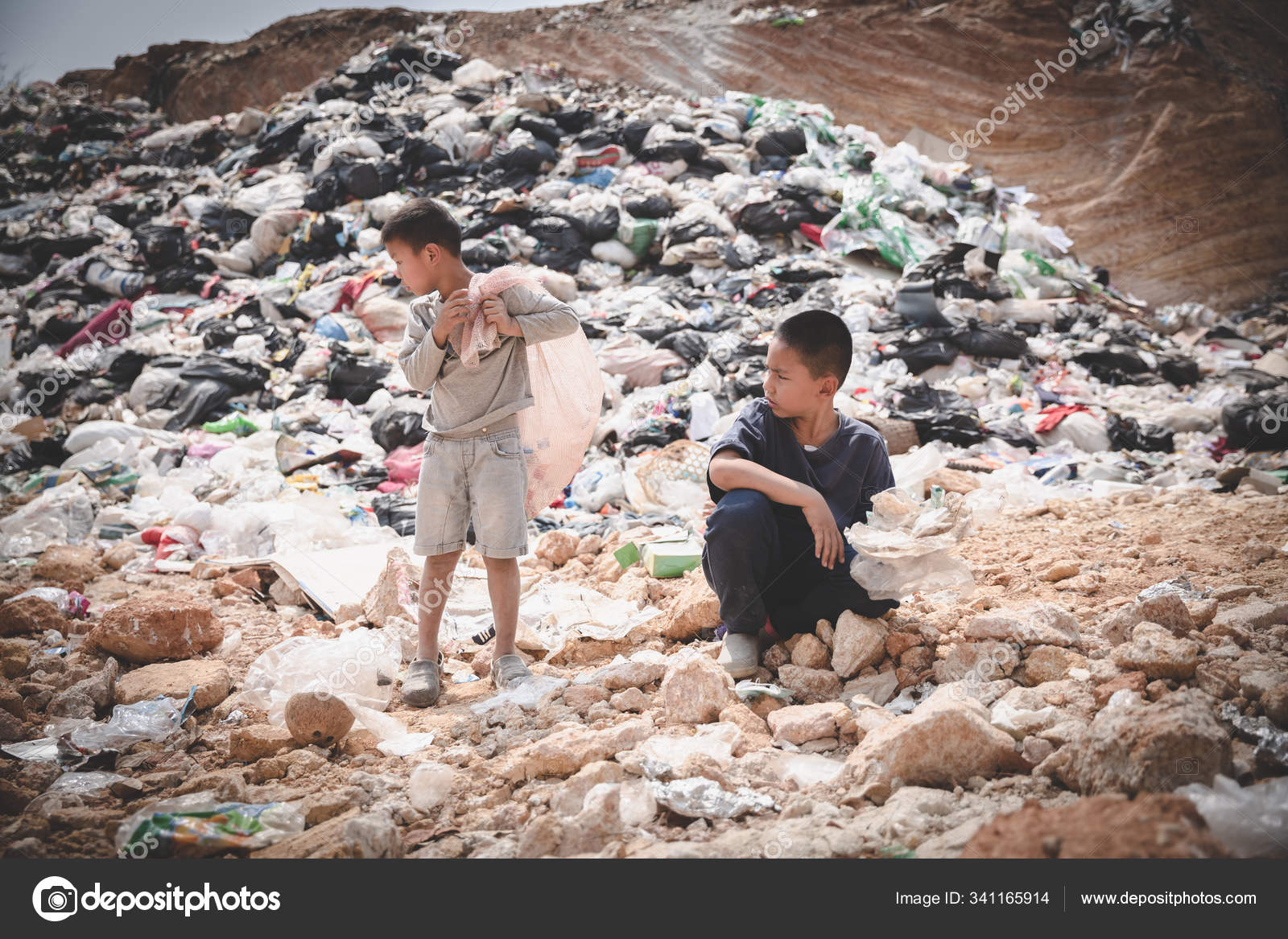 A poor boy collecting garbage waste from a landfill site in the — Stock ...