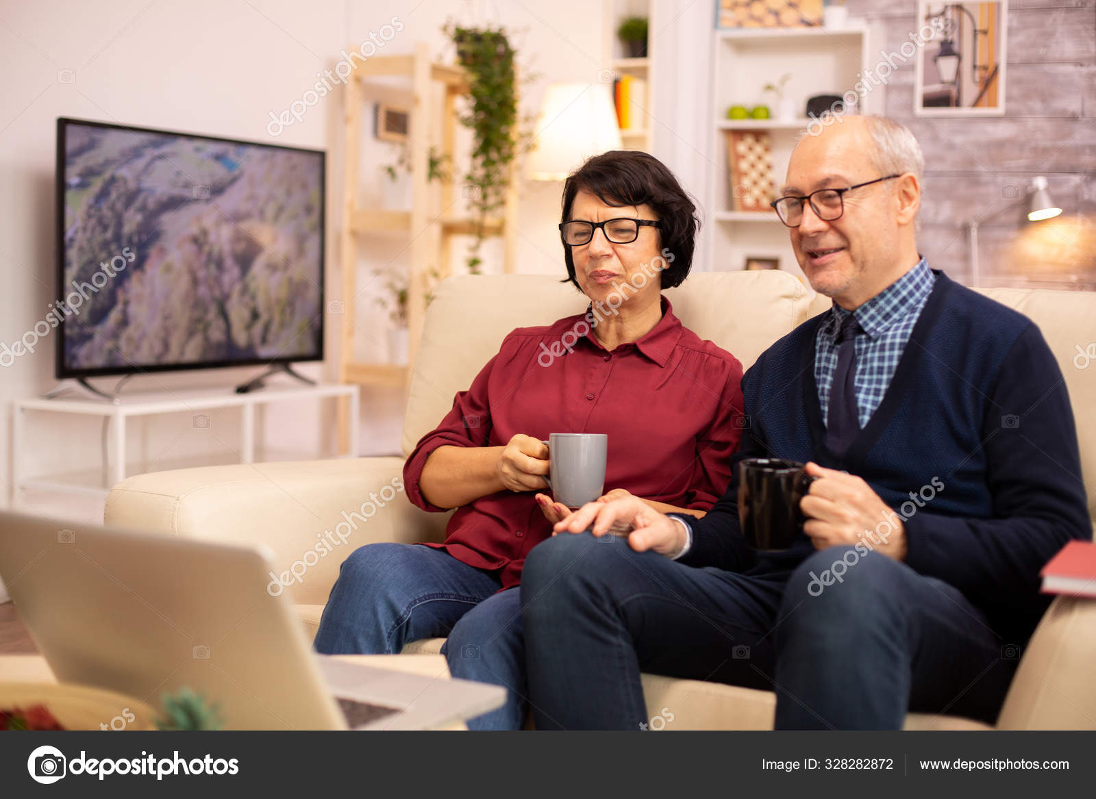 Elderly old couple using modern laptop to chat with their grandson ...
