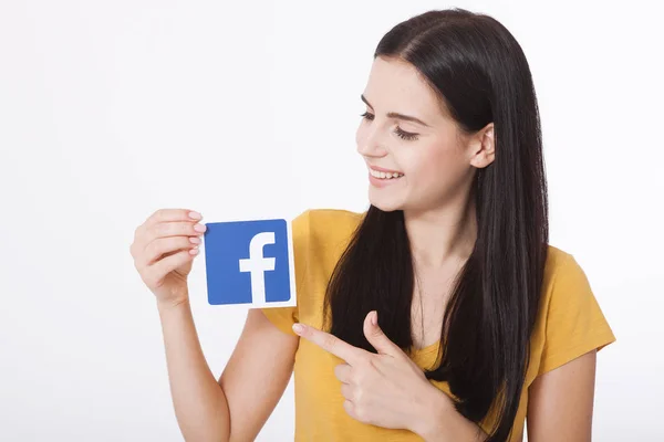 Hand holds Linkedin logo sign printed on paper on white background ...