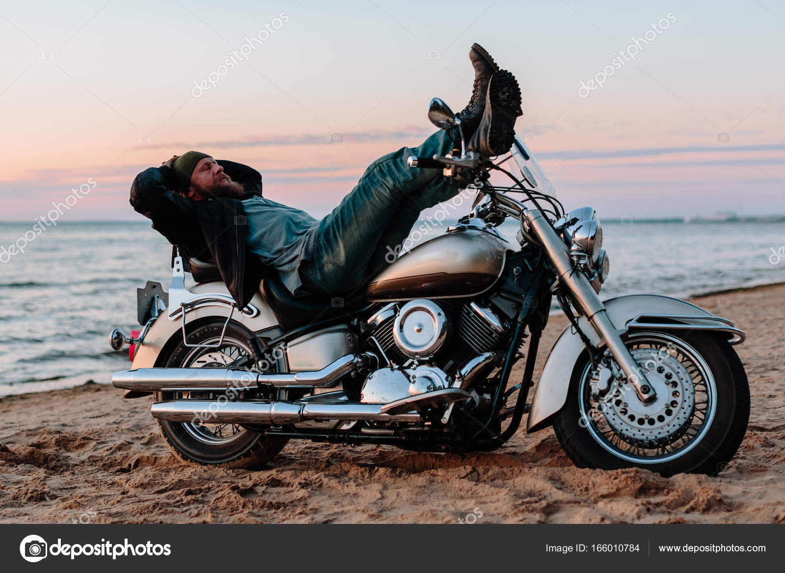 Man sleeping on a motorcycle on the beach at sunset – Stock Editorial ...