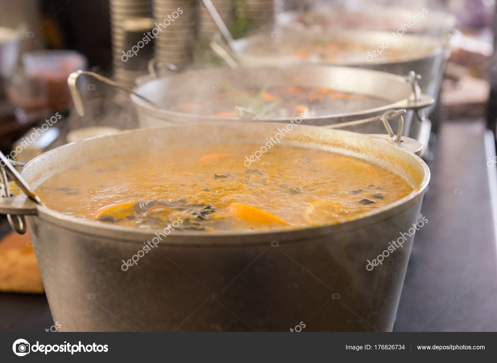 Spicy soup in large cauldrons with ladle inside at outdoor food Stock ...
