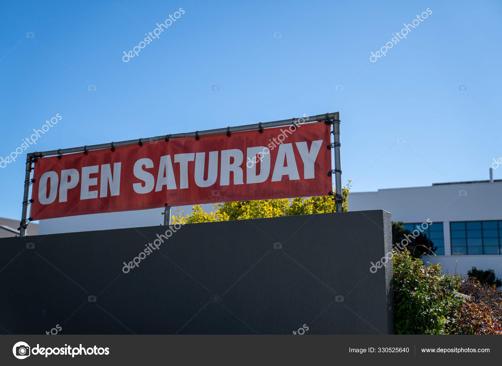 Open Saturday sign hanging on top of store building on sunny day ...