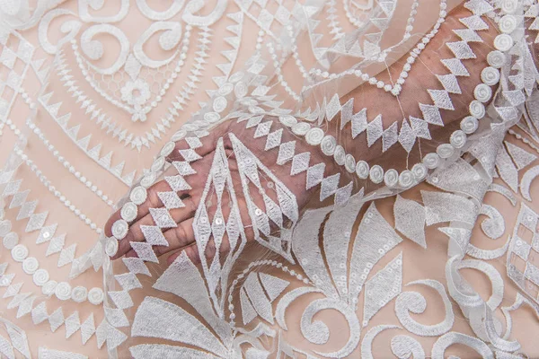 a background image of ivory-colored lace cloth. White lace on beige ...