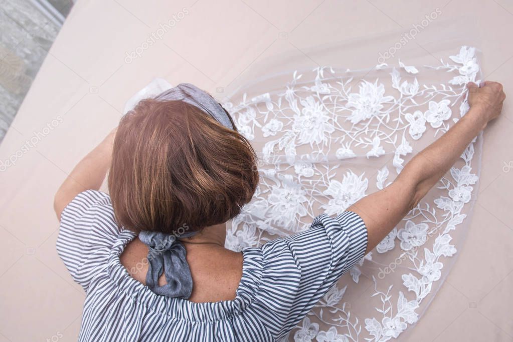 Costurera trabajando por hermoso vestido en atelier de boda. costurera ...