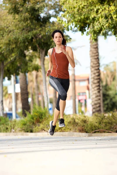 Full body portrait of healthy young sports woman running outdoors ...