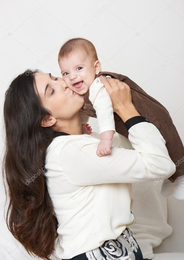 Mother raising baby and play, happy family portrait on white background ...
