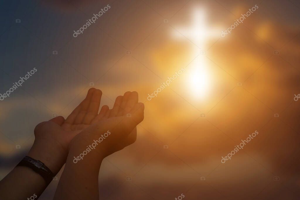 Silueta de manos abiertas cristianas para rezar por la bendición de Dios al atardecer. 2023