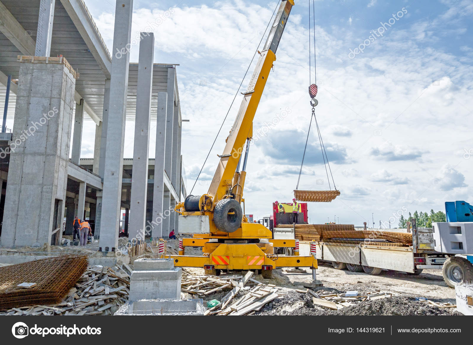 Mobile crane is carry pile of concrete armature, rusty square re Stock ...