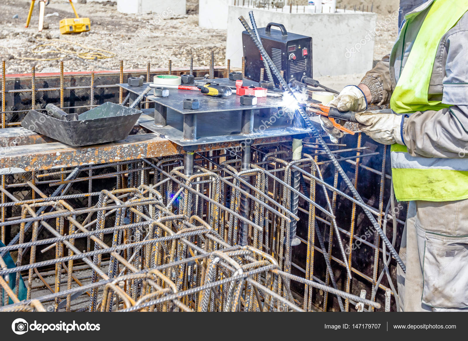 Assembling metal skeleton, welder is welding tied reinforcing ro ...