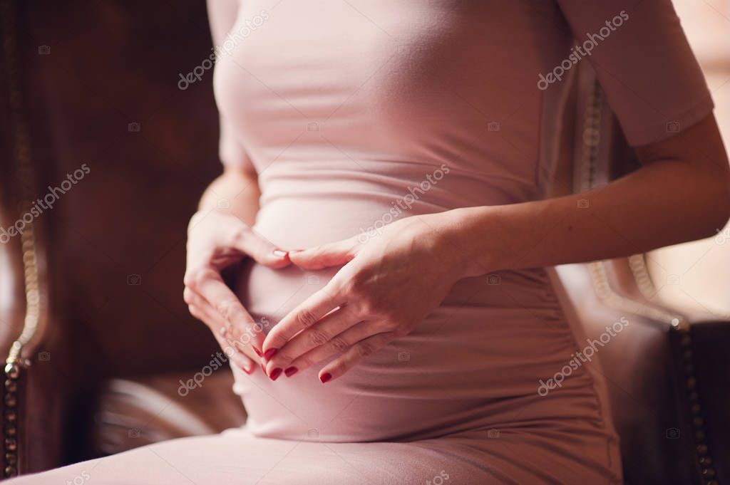 Mujer feliz embarazada tocando su vientre. Retrato de madre embarazada de mediana edad ...