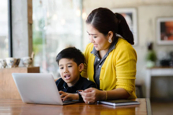 Happy Asian mother and her son raising their hands while win the Stock ...