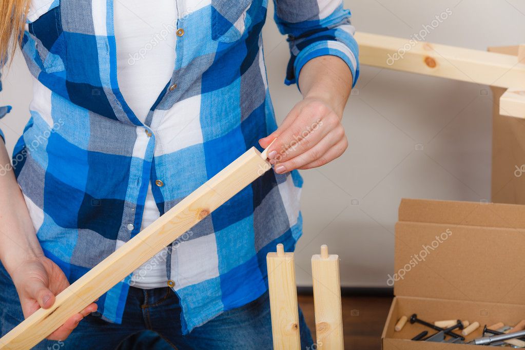 Human assembling wood furniture. DIY. Stock Photo by ©Voyagerix 125027452