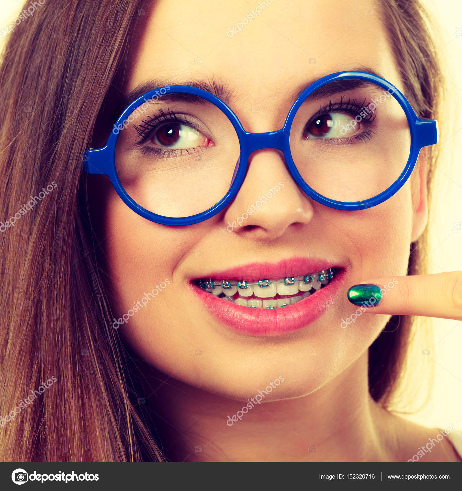 Nerdy woman showing her teeth with braces Stock Photo by ©Voyagerix 152320716
