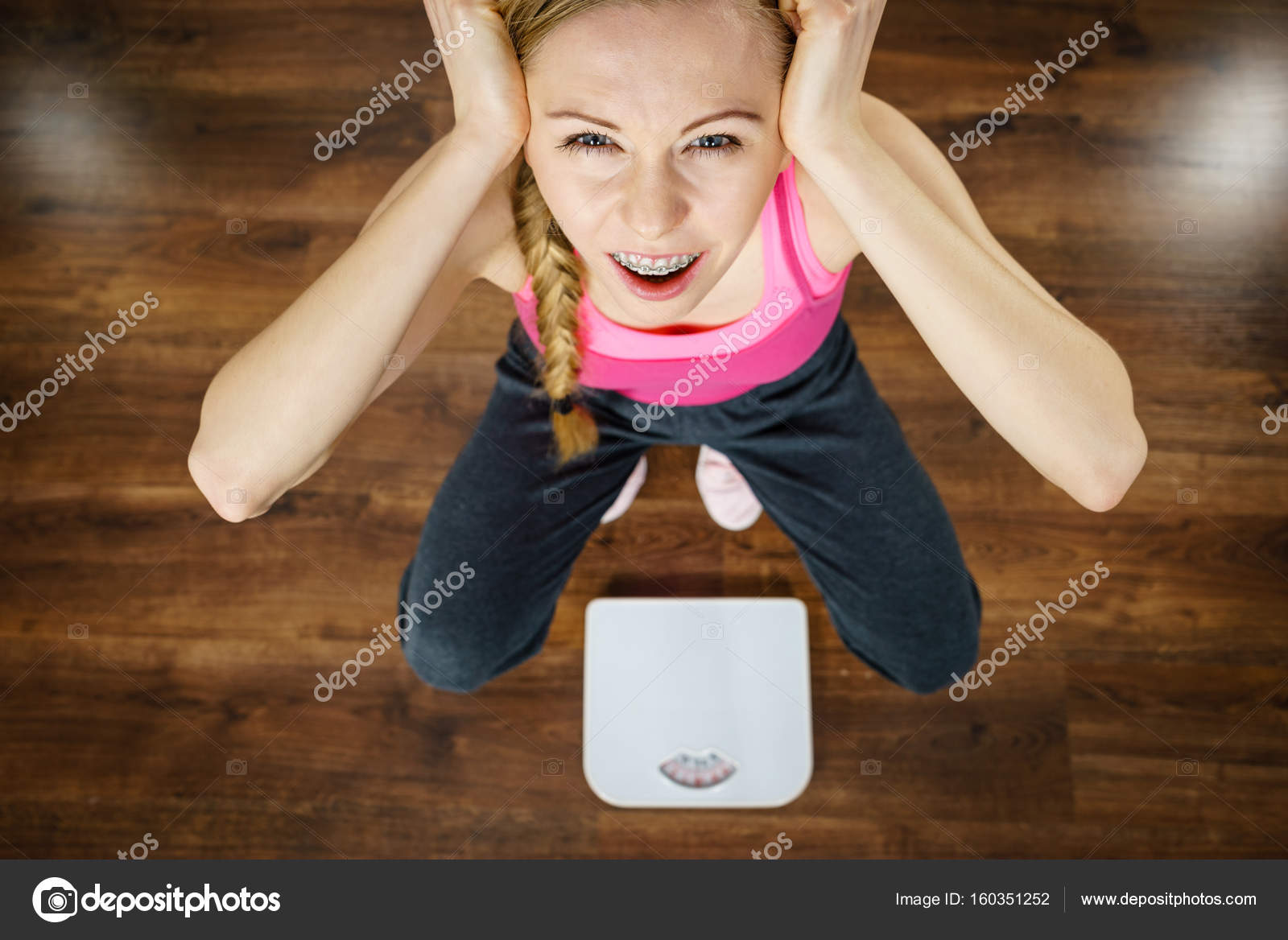 Scared woman on bathroom scale machine Stock Photo by ©Voyagerix 160351252