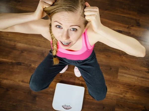 Scared woman on bathroom scale machine Stock Photo by ©Voyagerix 160351252