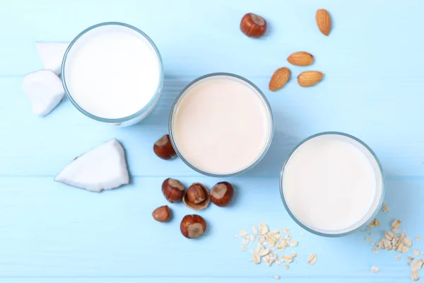 Different types of vegetable milk on the table. Coconut, oatmeal ...