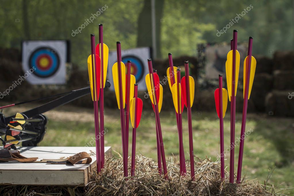 Tiro con arco y flechas de colores brillantes en un campo de tiro ...