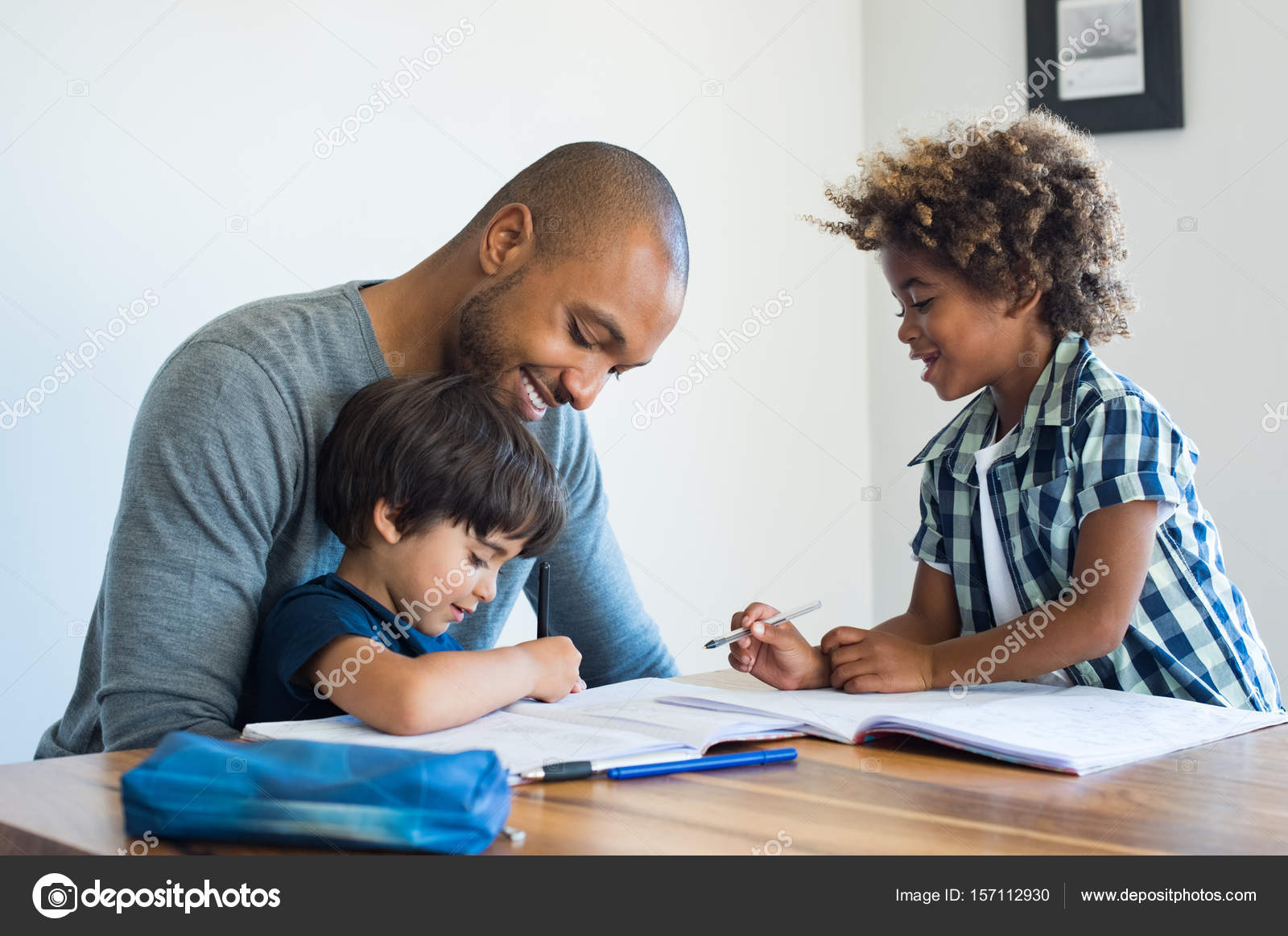 Father helping his sons with homework Stock Photo by ©ridofranz 157112930