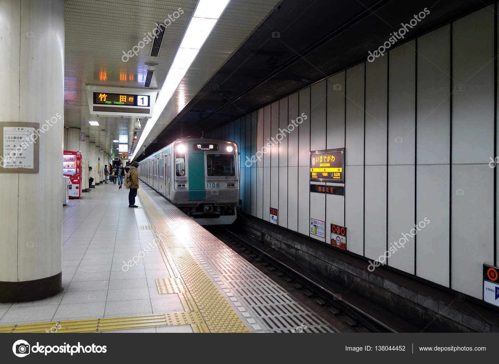 Unidentified Japanese wait for train on a platform in Kyoto, Jap ...