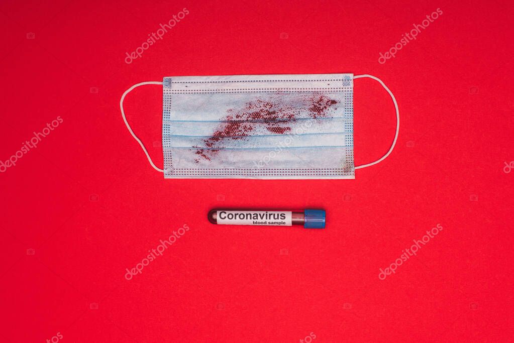 Vista superior de la máscara con sangre y probeta con muestra de sangre ...