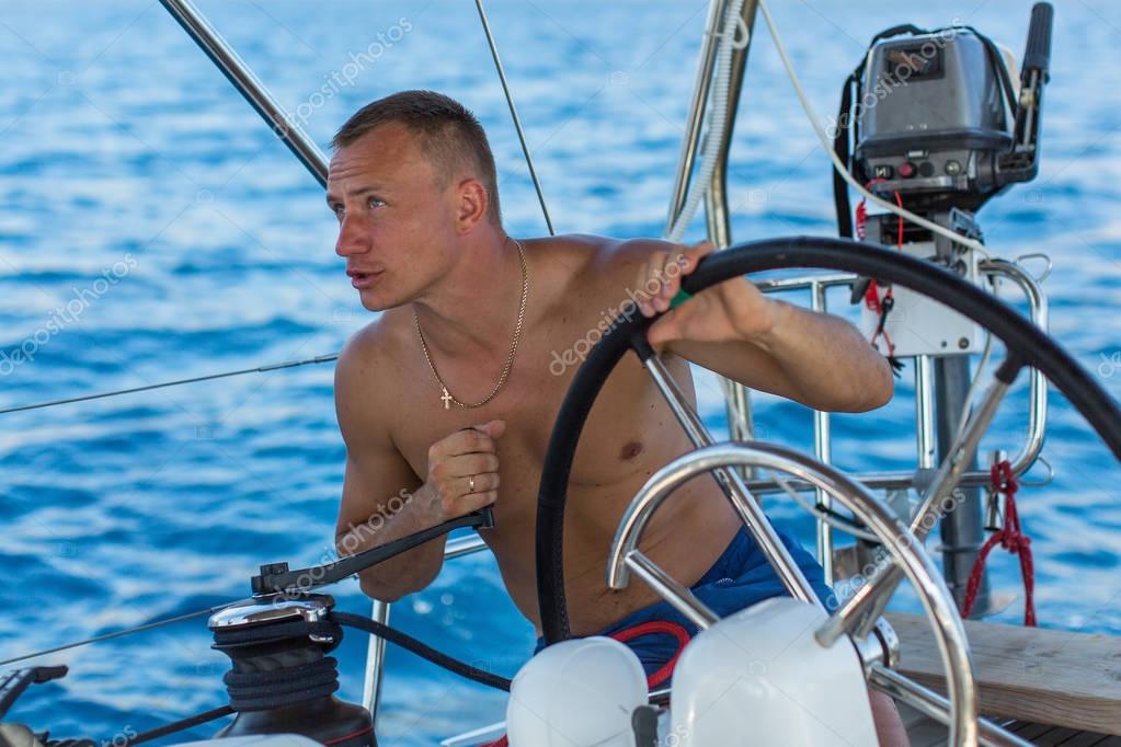 Young man skipper steers boat Stock Photo by ©dimaberkut 129270638