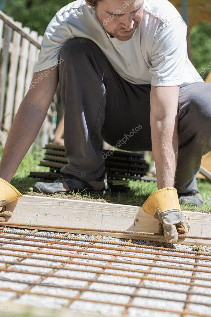 Hombre haciendo una red de barras de acero como refuerzo en un agujero para una fundaci n de ...