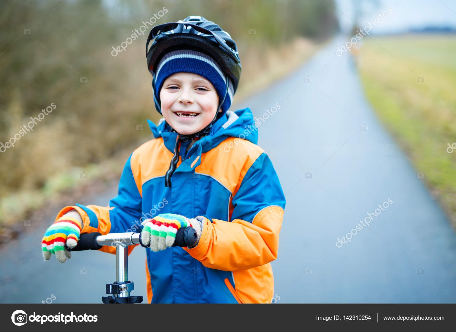 Cute preschool kid boy riding on scooter in park Stock Photo by ...