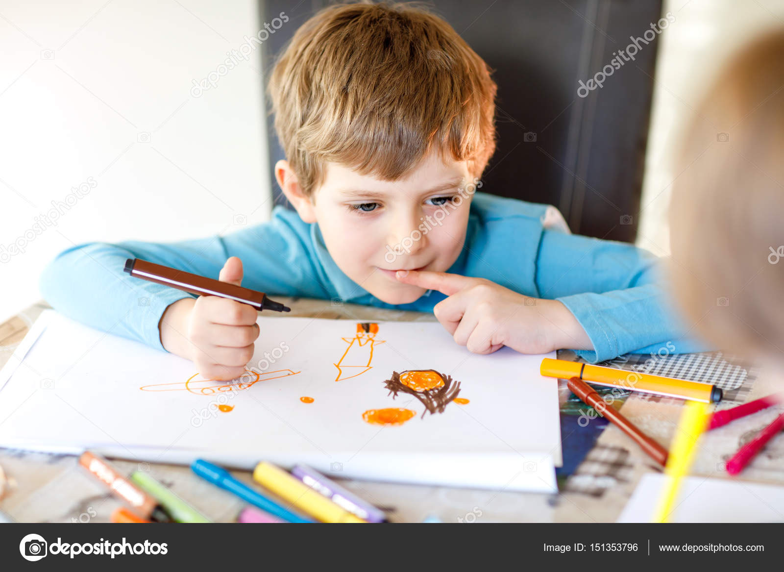 Preschool kid boy at home making homework, painting a story with ...
