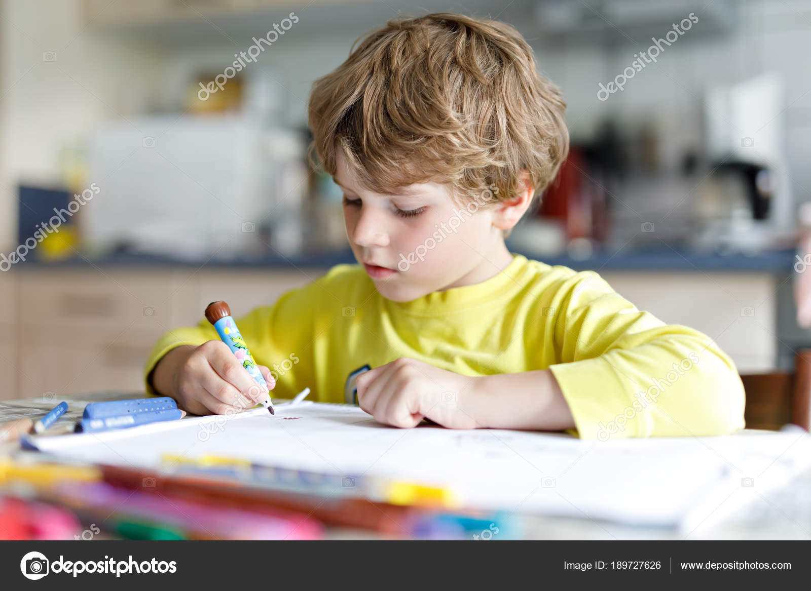 Tired kid boy at home making homework writing letters with colorful ...