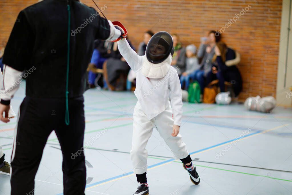 Peque o ni o esgrima en una competencia de vallas. Ni o en uniforme de ...