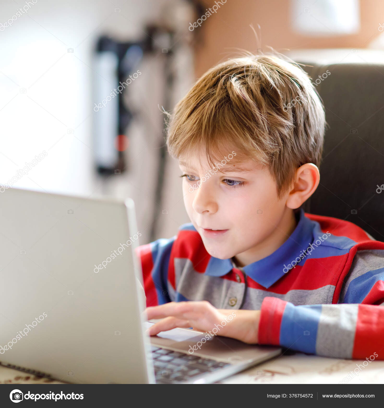 Little school kid making school homework on computer. Child learning on ...