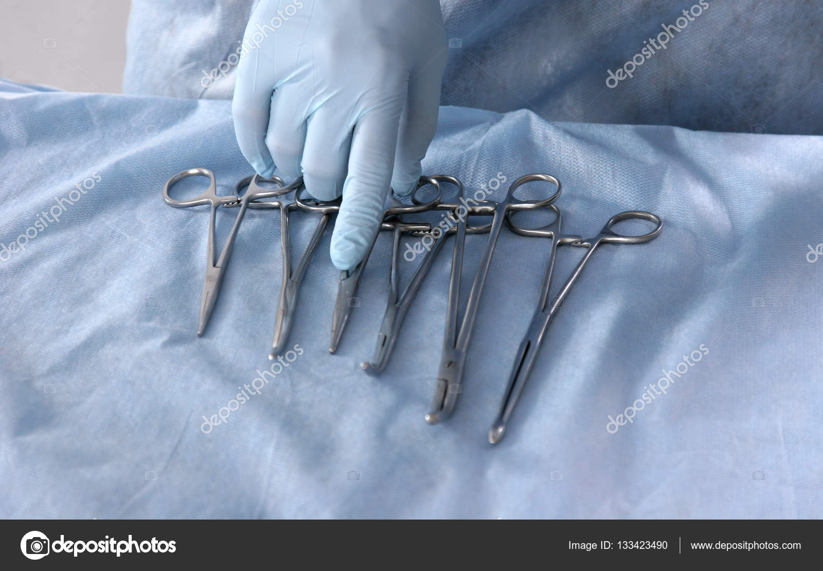 Surgeons hands holding and passing surgical instrument to other doctor ...