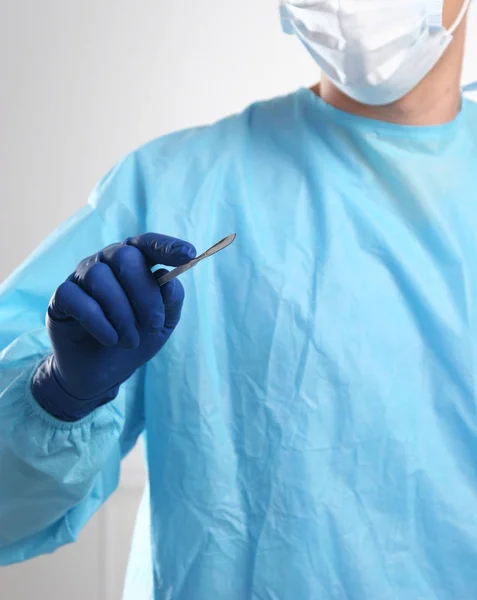 Man surgeon holds a scalpel in an operating room — Stock Photo © vicby ...