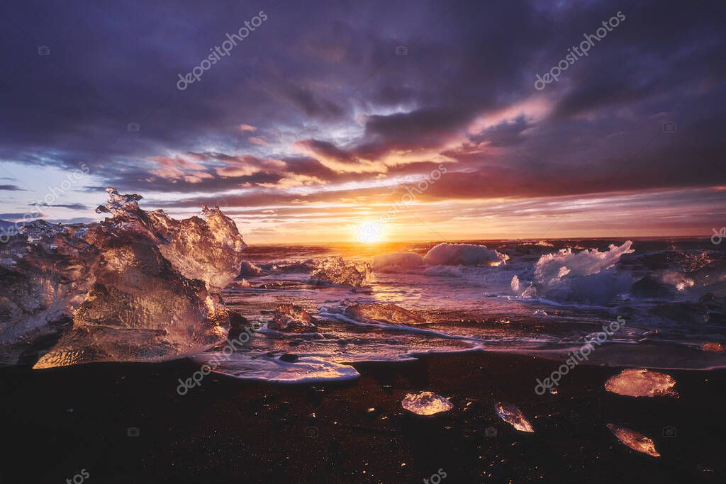Salida del sol en la playa de Diamond con los hielos de la laguna ...