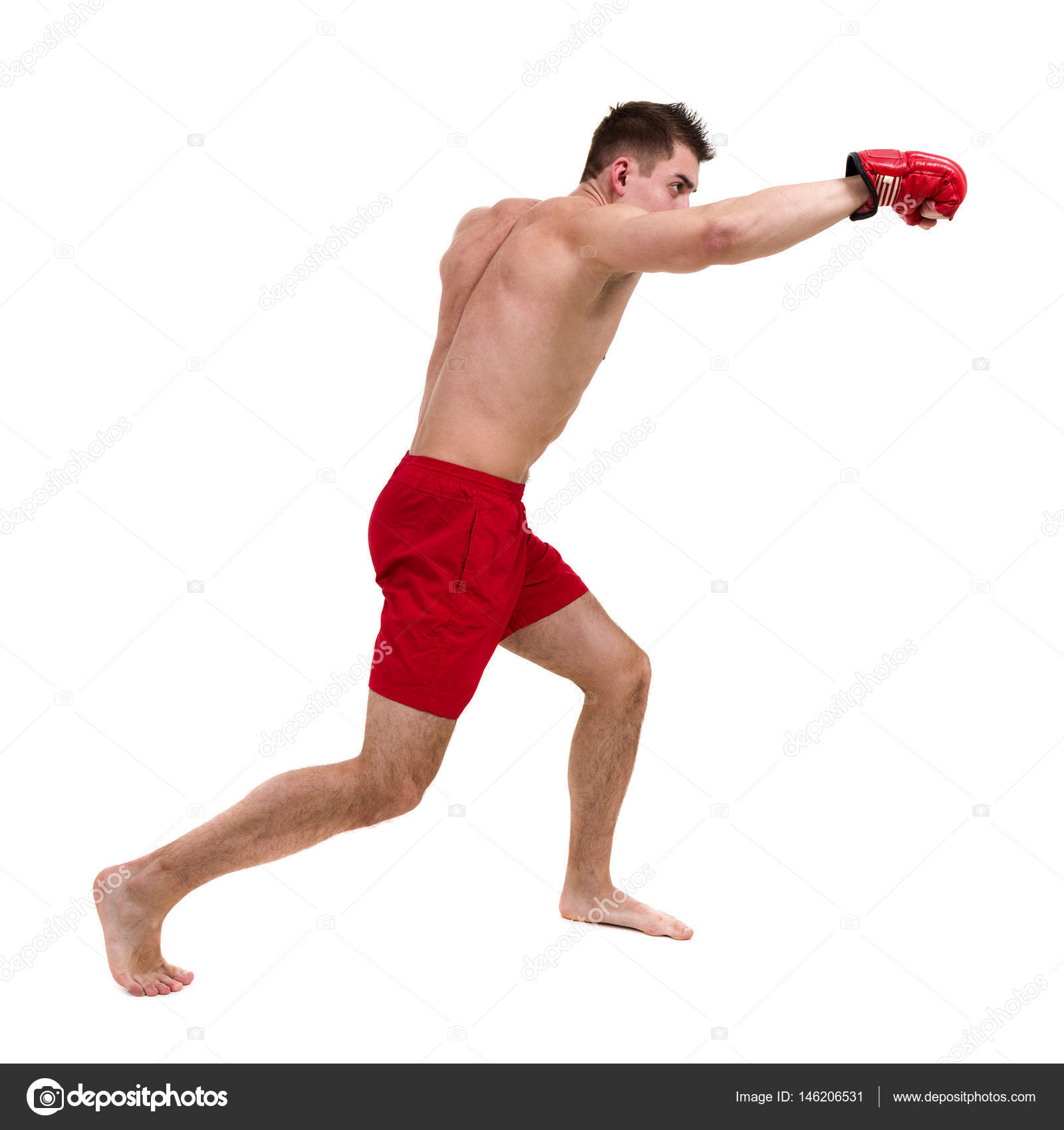 Full length portrait of young male boxer showing some movements against ...