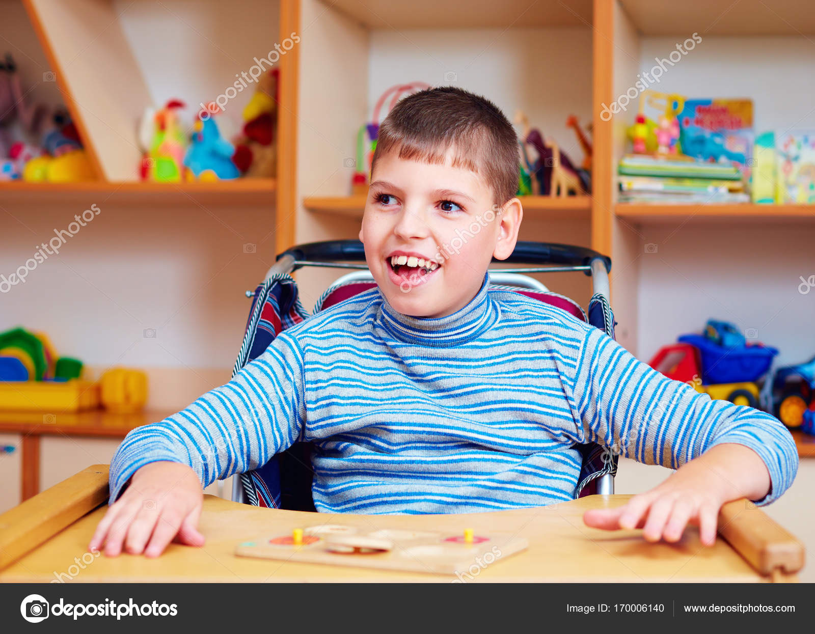 Cheerful boy with disability at rehabilitation center for kids with ...