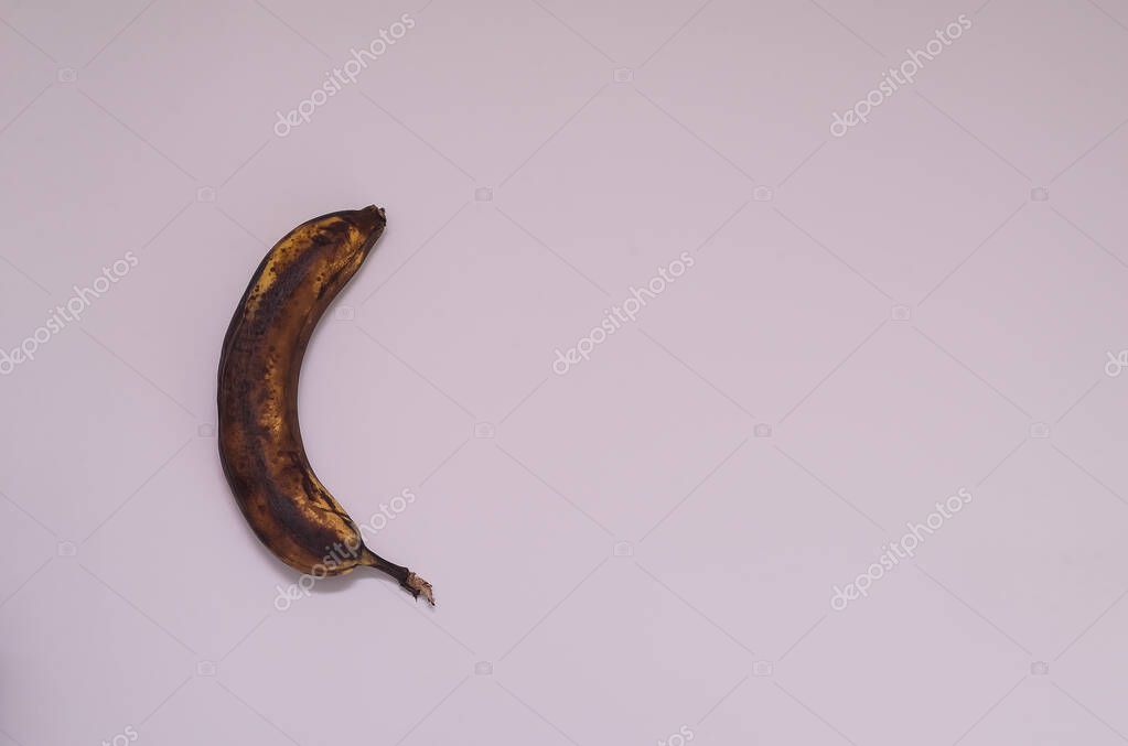 Comida fea. Plátano oscuro estropeado con el tiempo sobre un fondo ...