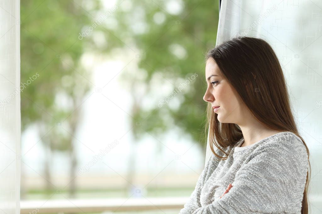 Longing woman looking through window at home — Stock Photo ...
