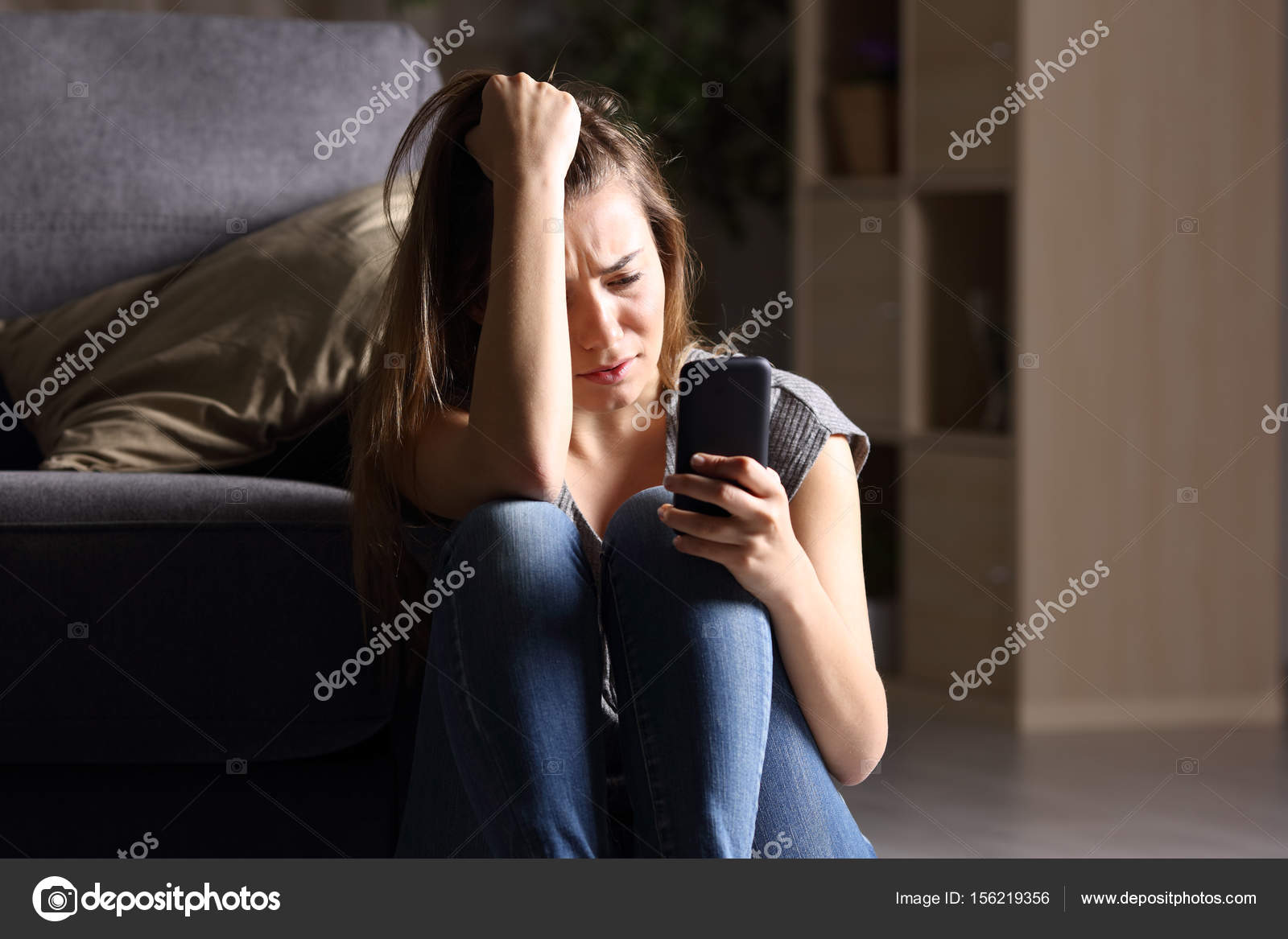 Sad teen checking phone at home — Stock Photo © AntonioGuillemF #156219356 Sad teen checking phone at home — Stock Photo © AntonioGuillemF #156219356