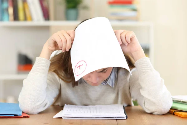 Sad student with a failed exam at home - Stock Image - Everypixel