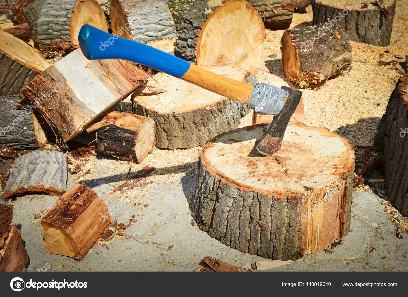 Ax stuck in a log of wood on a background of chopped wood Stock Photo ...